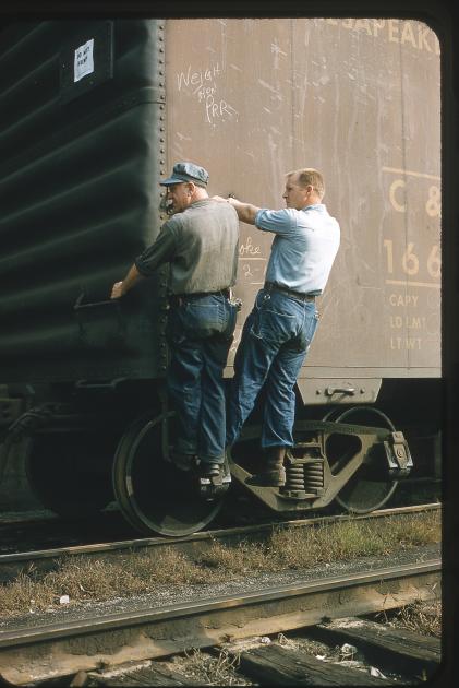 Workers riding C&O boxcar ladder | The Nickel Plate Archive