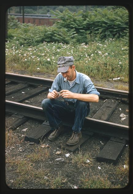 Worker sitting on rail smoking | The Nickel Plate Archive
